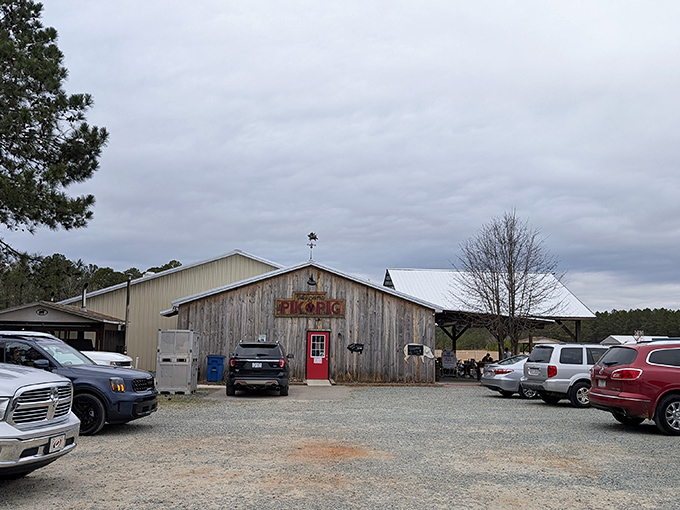 The weathered wooden exterior with that bold red door isn't trying to impress anyone—and that's precisely why it does. Southern barbecue authenticity at its finest.