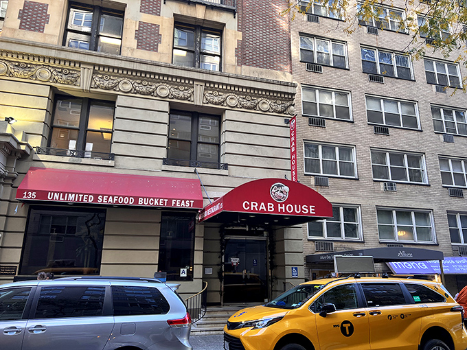 The bright red awning reading "UNLIMITED SEAFOOD BUCKET FEAST" works like a siren call to seafood lovers passing by on Manhattan's streets.