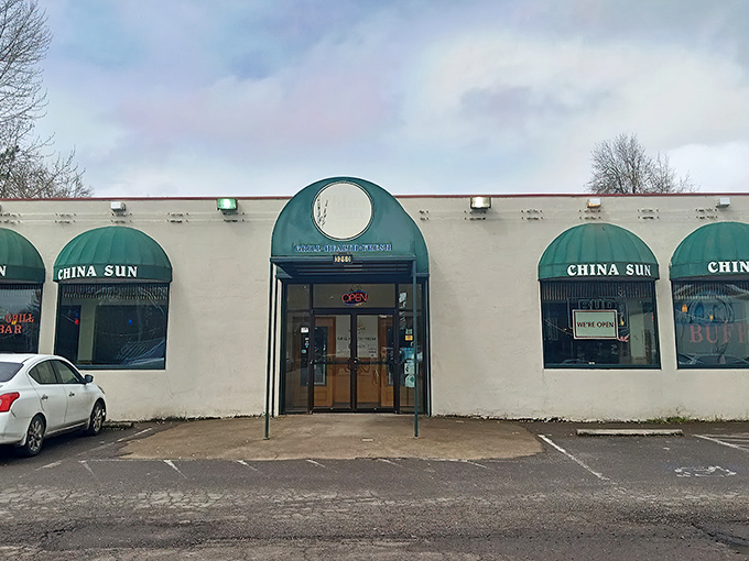 The distinctive green awnings of China Sun Buffet stand out against the white exterior, like beacons guiding hungry travelers to their destination.