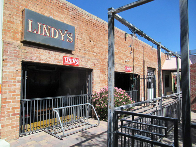 The unassuming brick exterior of Lindy's on 4th, complete with flame accents, stands as Tucson's temple to burger excess. Greatness often hides in plain sight.
