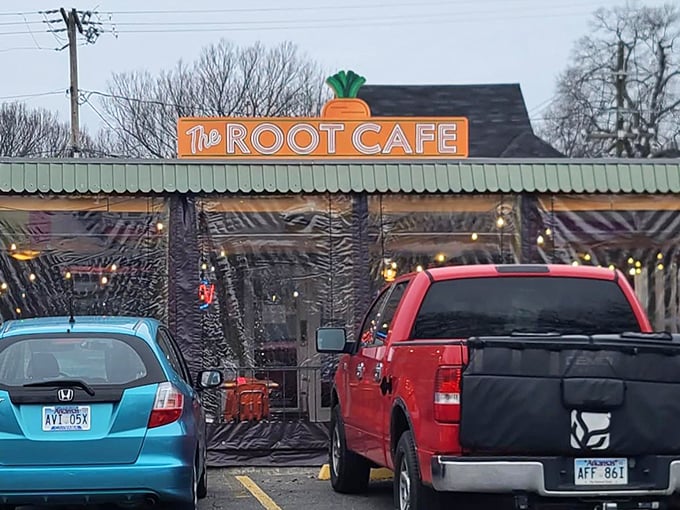 The unassuming exterior of The Root Cafe, where culinary magic hides behind a modest facade topped with that iconic carrot sign.