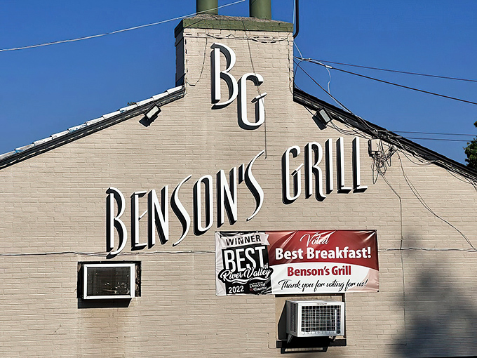 The unassuming exterior of Benson's Grill stands as a beacon to breakfast lovers. That parking sign might as well say "This way to happiness."