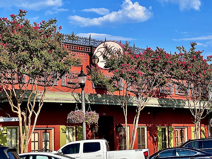 The vibrant red exterior of Mike's Place, framed by blooming crepe myrtles, stands as Conway's culinary beacon for seafood lovers.
