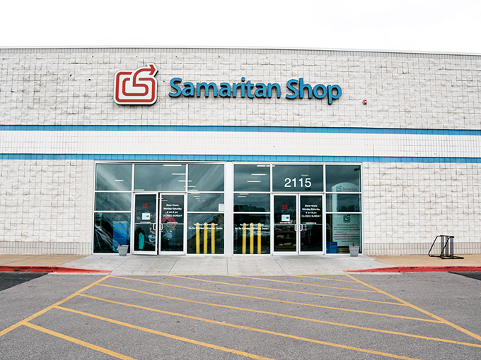 The exterior of Samaritan Shop stretches wide like a treasure chest waiting to be opened, its blue banner promising adventures in second-hand splendor.