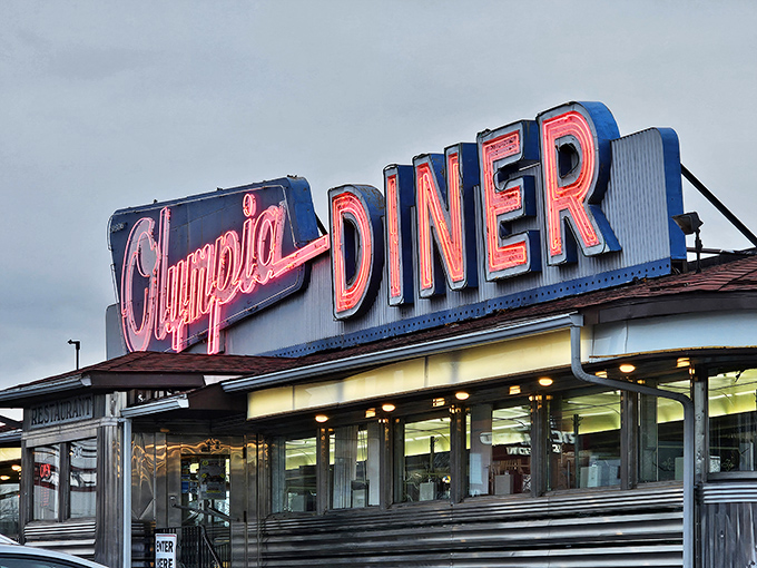 That neon sign isn't just advertising&mdash;it's a time machine. The Olympia's iconic blue and pink glow has been guiding hungry travelers home since Eisenhower was president.