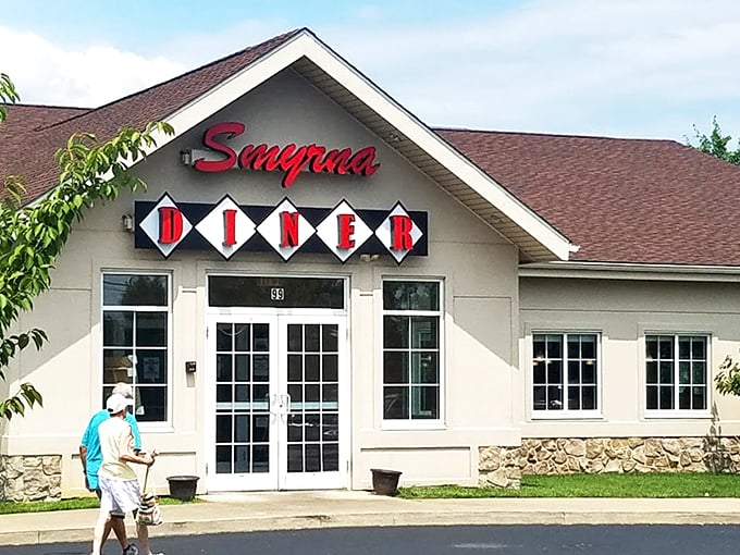 The Smyrna Diner stands proudly against a blue Delaware sky, its cream-colored exterior and distinctive sign promising comfort food salvation to hungry travelers and locals alike.