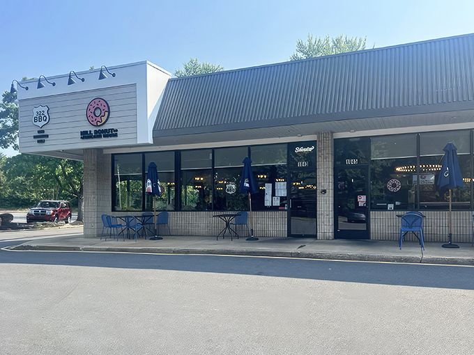 The pink donut sign beckons like a sugar-dusted lighthouse, guiding hungry travelers to this unassuming strip mall treasure in Wilmington.