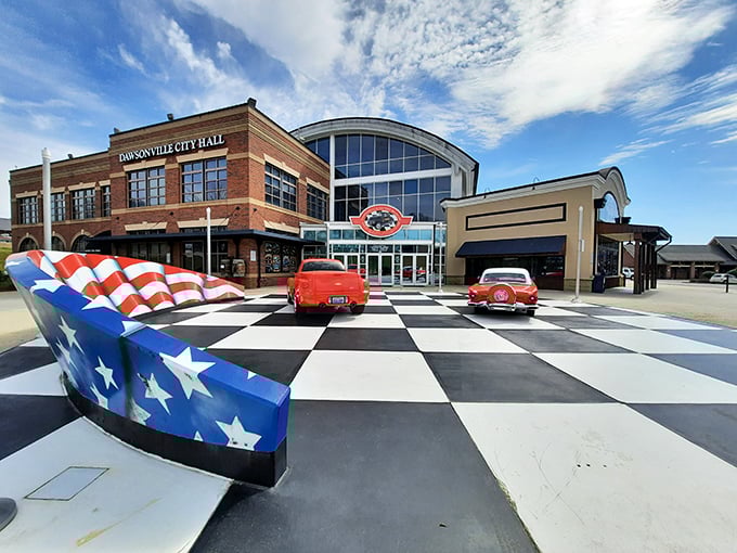 The checkered plaza welcomes speed enthusiasts like a starting line, with the sleek museum fa&ccedil;ade promising treasures that would make any gearhead's heart race faster than a qualifying lap.