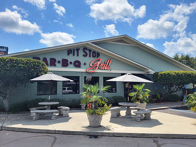 The mint-green sanctuary of smoke beckons from the roadside, with stone tables promising a moment of barbecue bliss before you even step inside.