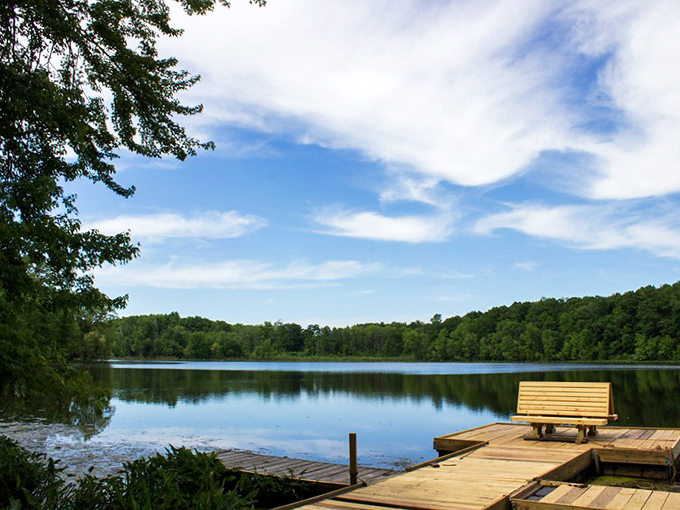 The perfect invitation to pause: A wooden bench overlooking one of Chain O'Lakes' serene waters, waiting just for you.