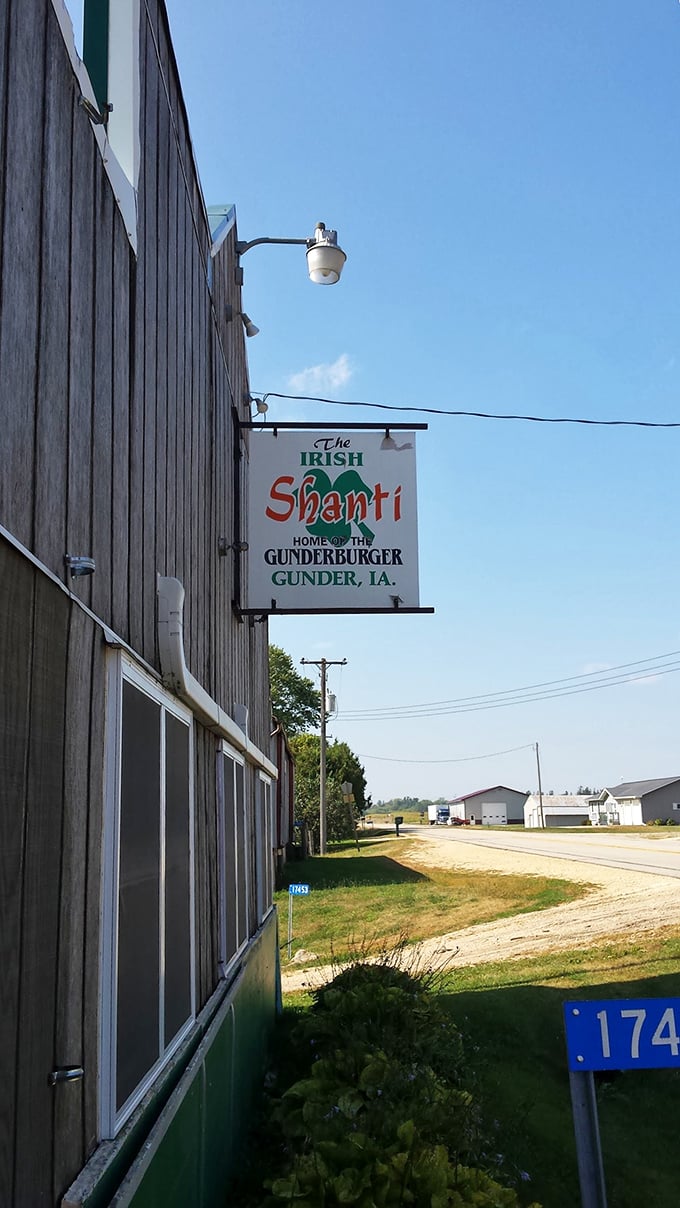 The weathered wooden exterior of Gunder Roadhouse stands as a beacon for burger pilgrims, its simple sign promising legendary satisfaction inside.