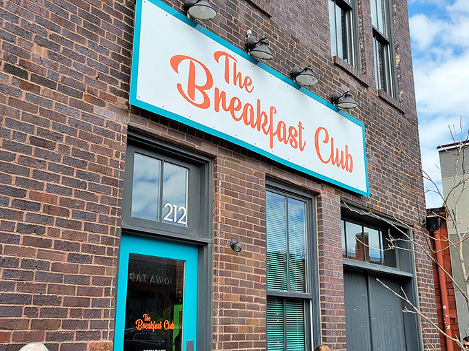 The turquoise-framed sign against rustic brick promises a breakfast revolution hiding behind that unassuming door at 212 East 3rd Street.