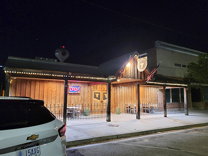 The Hoof & Horn's wooden facade glows with string lights against the Kansas night sky, like a beacon for hungry travelers.