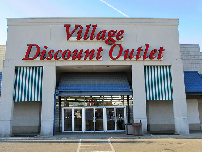 The iconic red signage of Village Discount Outlet beckons like a lighthouse for bargain hunters. Blue awnings and a spacious parking lot welcome treasure seekers of all kinds.