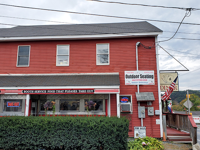 The cherry-red exterior of Four Aces Diner stands out like a winning hand in West Lebanon, beckoning hungry travelers with its classic Americana charm.