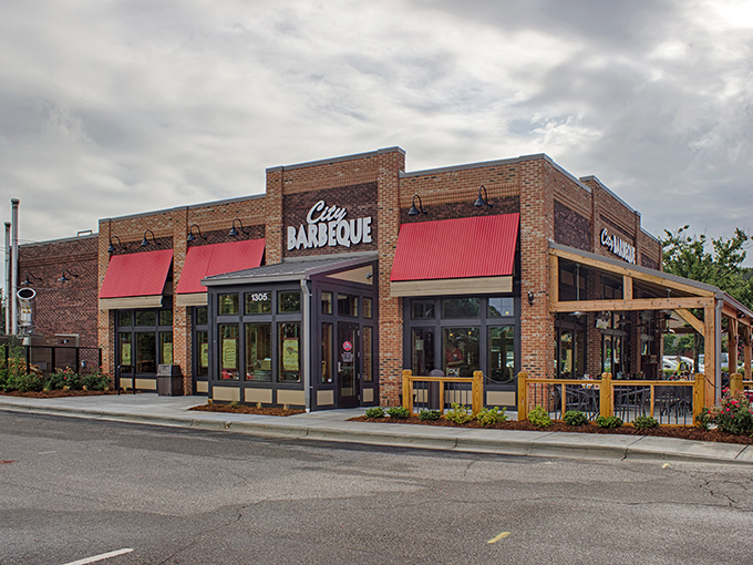 The brick fortress of flavor stands proud with its metal roof and welcoming red umbrellas&mdash;a barbecue beacon calling hungry travelers home.
