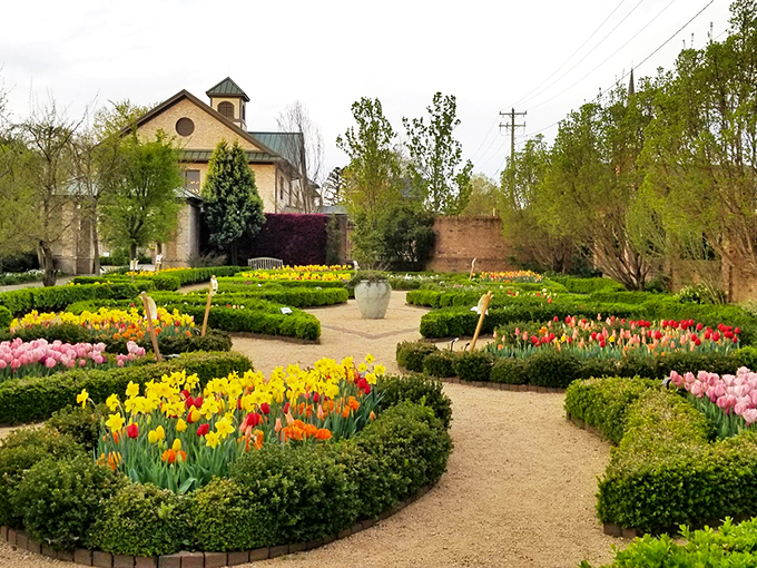 The elegant brick visitor center stands sentinel over a geometric paradise of boxwood hedges and golden daffodils&mdash;nature's version of architectural perfection.