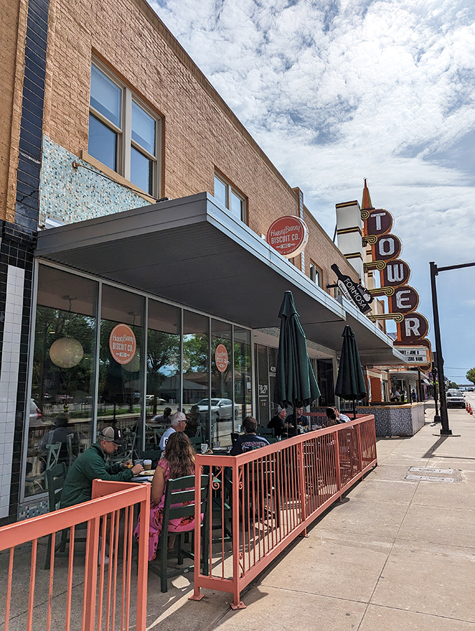 The coral-railed patio at HunnyBunny beckons like a breakfast siren song, with the iconic Tower Theater sign standing guard nearby.