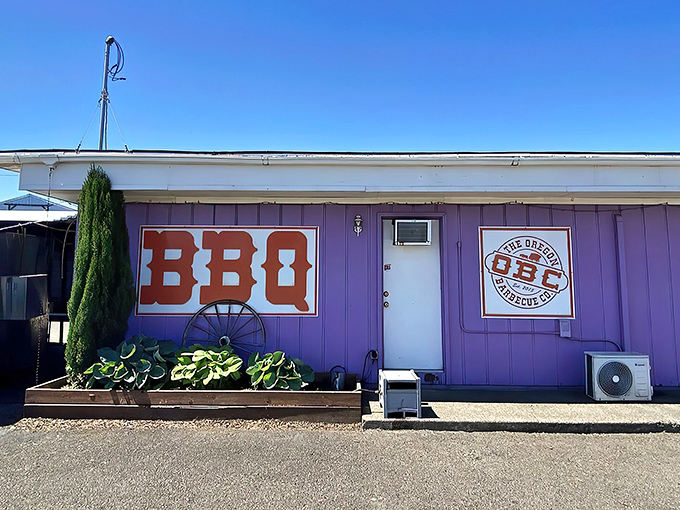 The unmistakable purple exterior of Oregon Barbecue Company stands out like a beacon for hungry travelers, promising smoky delights within.