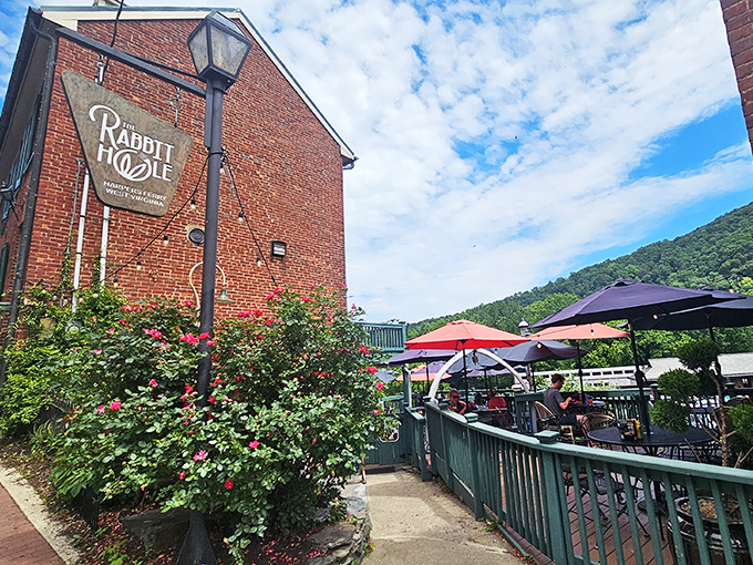 The brick exterior of The Rabbit Hole beckons like a storybook invitation, complete with climbing roses and mountain views that make waiting for a table feel like a vacation.