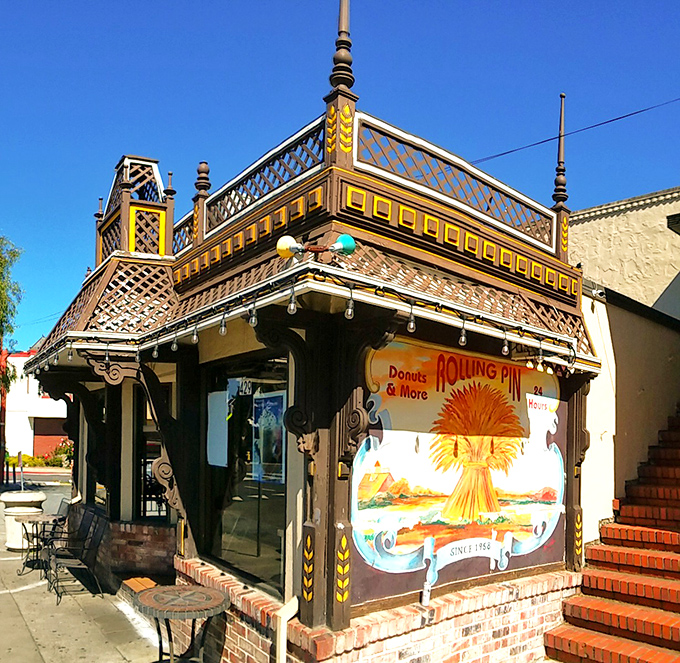 The storybook exterior of Rolling Pin Donuts stands like a beacon of sweetness on San Bruno's El Camino Real, promising delicious treasures within.