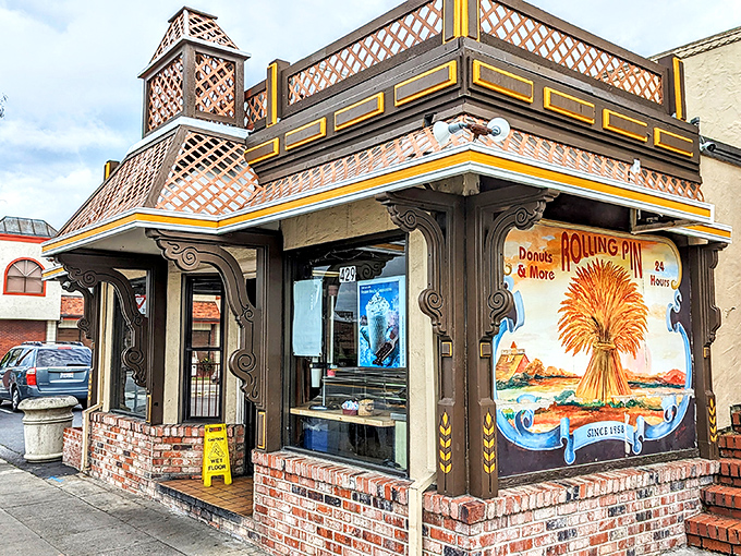 The storybook exterior of Rolling Pin Donuts stands like a beacon of sweetness on San Bruno's El Camino Real, promising delicious treasures within.