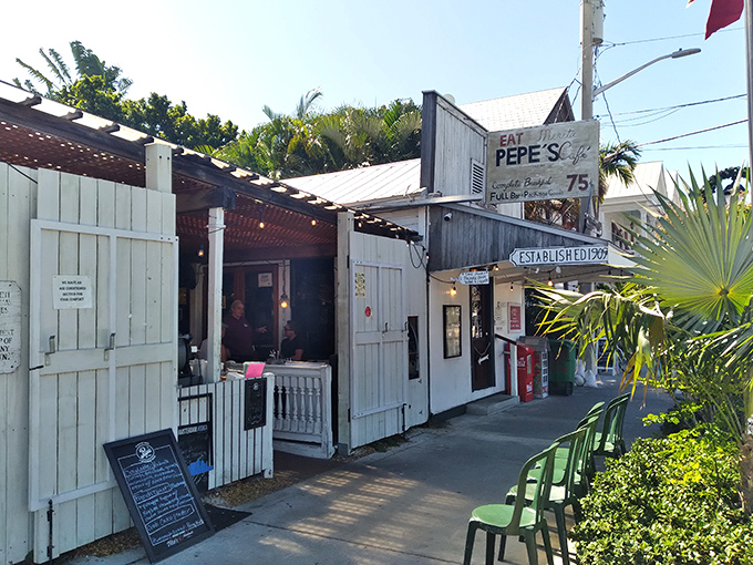 The weathered white clapboard exterior of Pepe's Cafe stands as a time capsule of Old Key West charm, beckoning hungry travelers with promises of island-time breakfast delights.