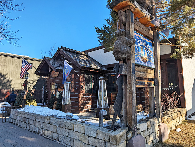 The log cabin exterior of The Kneadery welcomes hungry travelers with rustic charm and hanging flower baskets that say "Yes, breakfast is worth the drive."