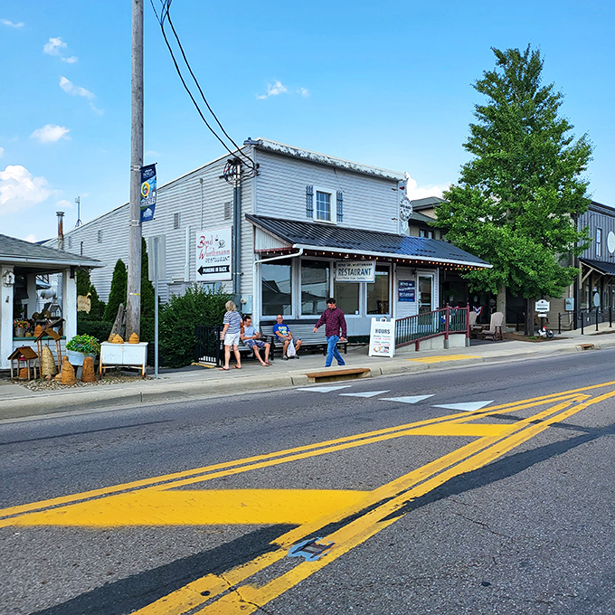 The unassuming white clapboard exterior of Boyd & Wurthmann stands like a time capsule on Berlin's main street, complete with that inviting green bench where friendships begin.