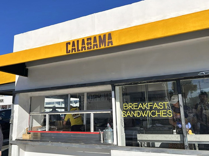 The corner of Santa Monica Boulevard where breakfast dreams come true. That yellow awning is like a culinary lighthouse guiding hungry souls to sandwich salvation.