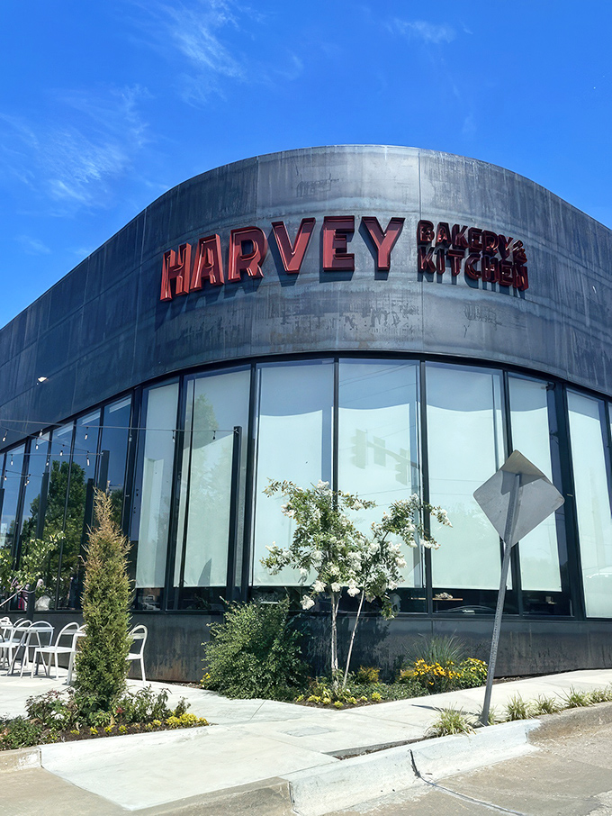 The curved modernist facade of Harvey Bakery & Kitchen stands as a bold architectural statement, its red signage beckoning hungry Oklahomans like a breakfast lighthouse. 