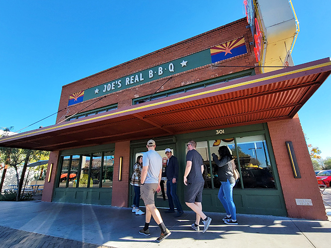 The brick facade of Joe's Real BBQ stands proudly on Gilbert's main drag, Arizona flags flanking its name like sentinels guarding a smoky treasure.