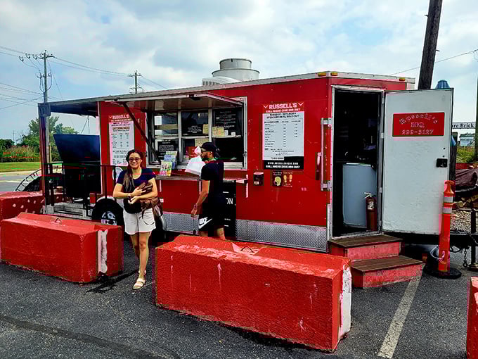 The bright red food trailer stands out like a culinary lighthouse, beckoning hungry travelers with its no-nonsense approach to serious barbecue.