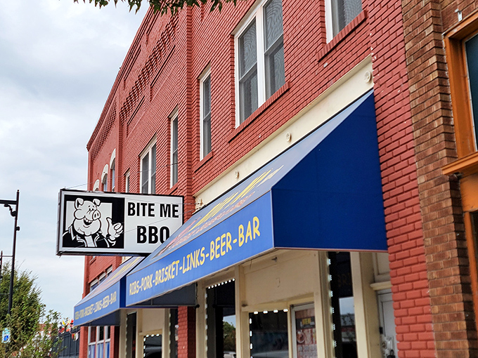 The bright blue awning of Bite Me BBQ stands out like a beacon of smoky hope on Wichita's St. Francis Street, promising delicious rebellion in every bite.