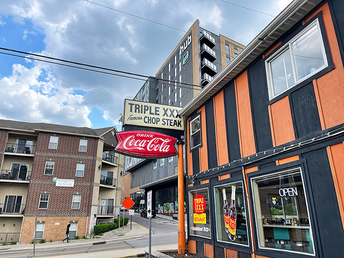 The iconic orange and black striped exterior stands defiant against modern architecture, like a time traveler who refuses to update their wardrobe. Pure Americana.