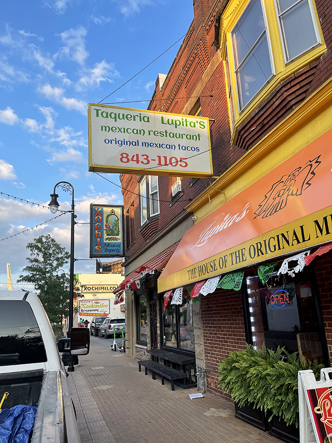 The bright orange awning of Taqueria Lupitas stands out like a beacon of culinary hope on this Detroit street corner, promising authentic Mexican flavors within.