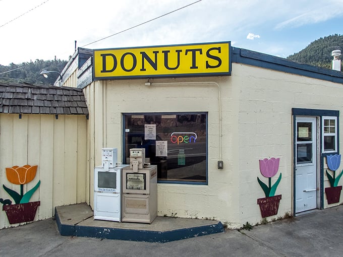 The unassuming exterior of Donut Haus stands like a beacon of sugary hope against the majestic Rocky Mountain backdrop. Sweet treasures await inside.