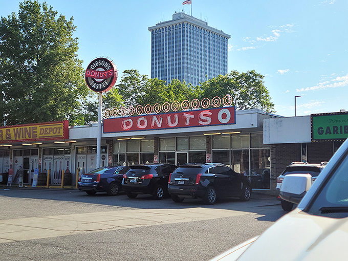 The iconic Gibson's Donuts storefront stands proudly against Memphis' skyline, a beacon of fried dough perfection for early risers and night owls alike.