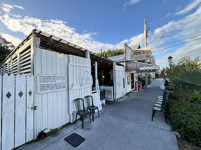 The weathered white clapboard exterior of Pepe's Cafe stands as a time capsule of Old Key West charm, beckoning hungry travelers with promises of island-time breakfast delights.
