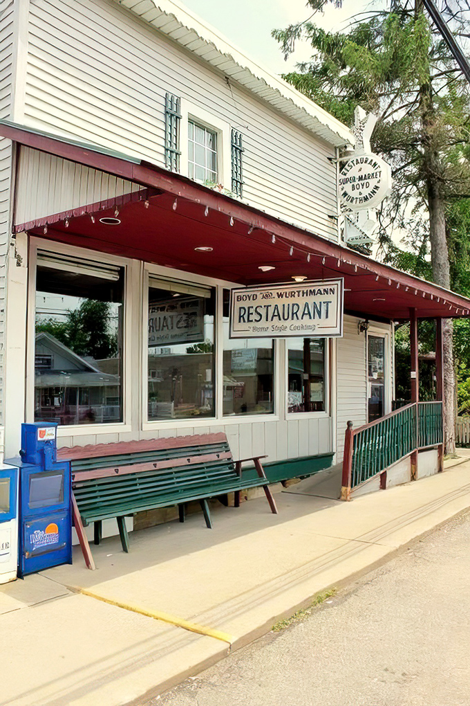 The unassuming white clapboard exterior of Boyd & Wurthmann stands like a time capsule on Berlin's main street, complete with that inviting green bench where friendships begin.