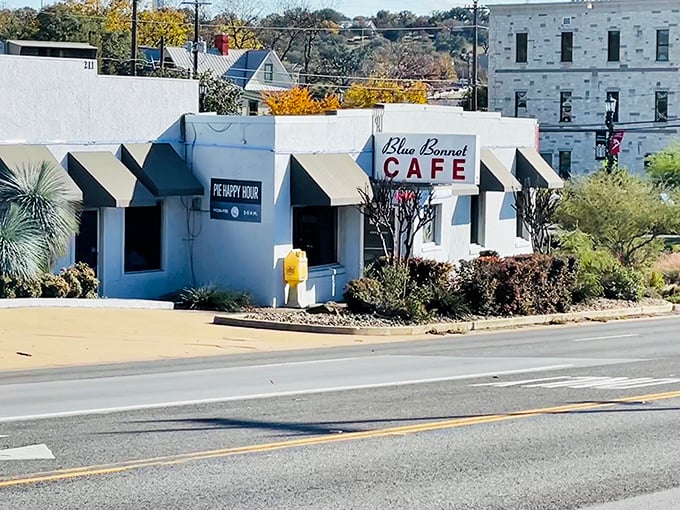 The unassuming exterior of Blue Bonnet Cafe stands like a beacon of hope for hungry travelers. Texas sunshine and pie await.