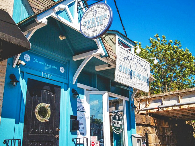 The blue fa&ccedil;ade of Trolley Square Oyster House stands like a maritime beacon in Wilmington, promising seafood treasures within those weathered wooden signs.