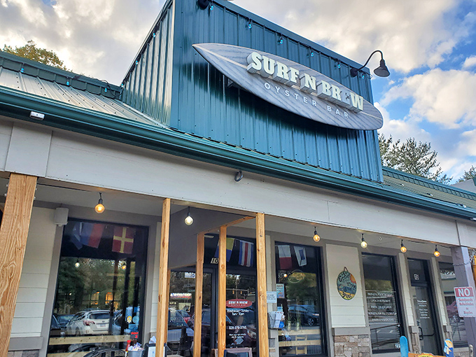 The surfboard sign announces your arrival at seafood paradise – where mountain air meets maritime flavor in Fletcher's unexpected coastal outpost.