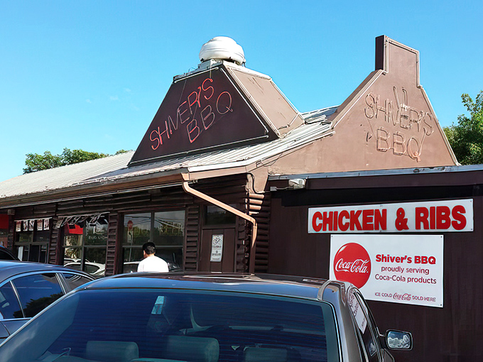 The iconic red roof of Shiver's BBQ stands like a barbecue beacon in Homestead, promising smoky delights under Florida's endless blue sky.