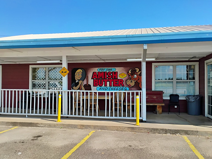 The welcoming front porch of Amish Country Store beckons with its classic red siding, white railings, and that charming "Amish Buggy Xing" sign that promises authentic flavors await inside.