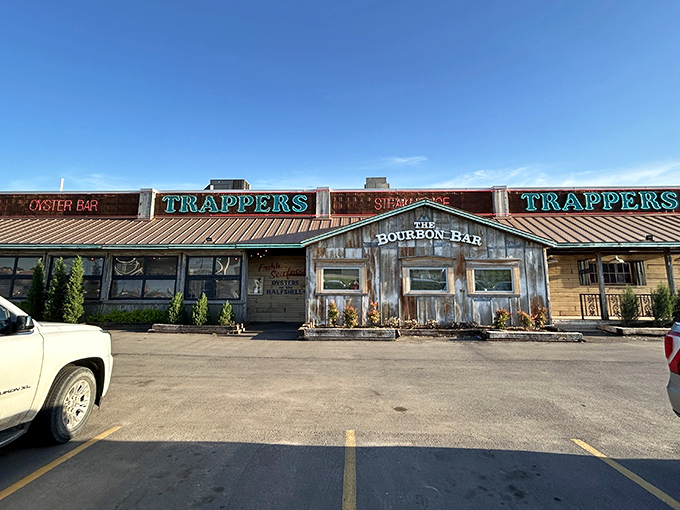 The rustic wooden facade of Trapper's beckons like an old friend, promising comfort food with Cajun flair beneath those neon signs.