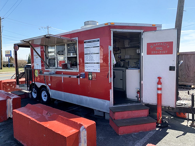 The bright red food trailer stands out like a culinary lighthouse, beckoning hungry travelers with its no-nonsense approach to serious barbecue.