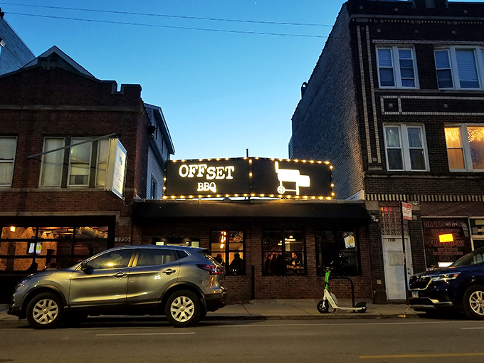 The glowing Offset BBQ sign beckons like a lighthouse for the hungry&mdash;Chicago's barbecue beacon against the twilight sky.
