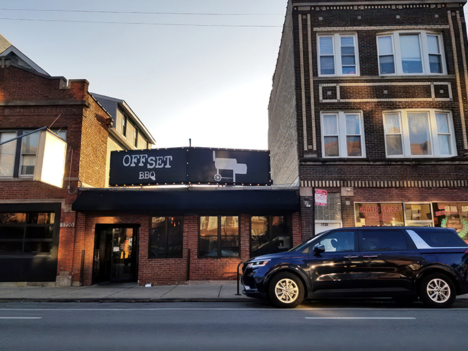 The glowing Offset BBQ sign beckons like a lighthouse for the hungry&mdash;Chicago's barbecue beacon against the twilight sky. 