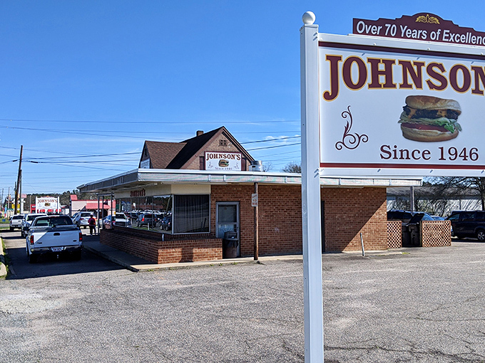 The unassuming brick exterior of Johnson's Drive-In has welcomed burger pilgrims since 1946, proving that greatness rarely needs fancy packaging. 